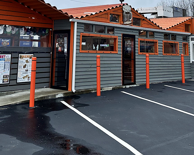 The unassuming gray exterior with bright orange trim stands like a time capsule of Americana, beckoning hungry travelers with promises of nostalgic flavors.