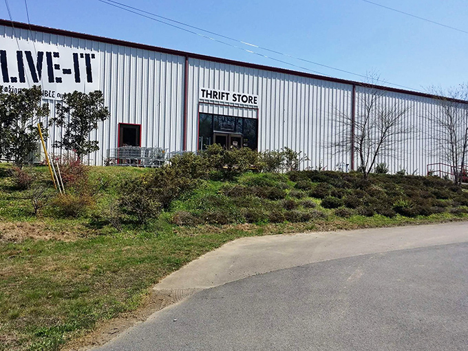 The unassuming exterior of LIVE-IT Thrift Store stands like a treasure chest waiting to be opened, complete with wooden ramp entrance and colorful directional sign.