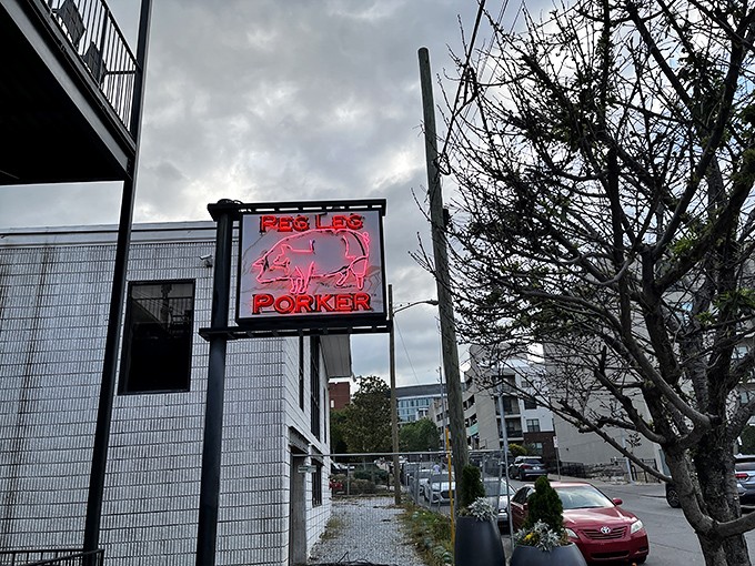 The neon pig sign glows like a barbecue beacon against Nashville's skyline, promising smoky salvation to hungry souls wandering The Gulch.