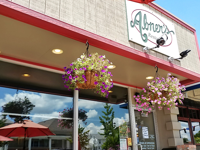 Abner's welcoming exterior beckons with colorful flower baskets and cheerful red umbrellas&mdash;like finding the neighborhood living room you never knew you needed.