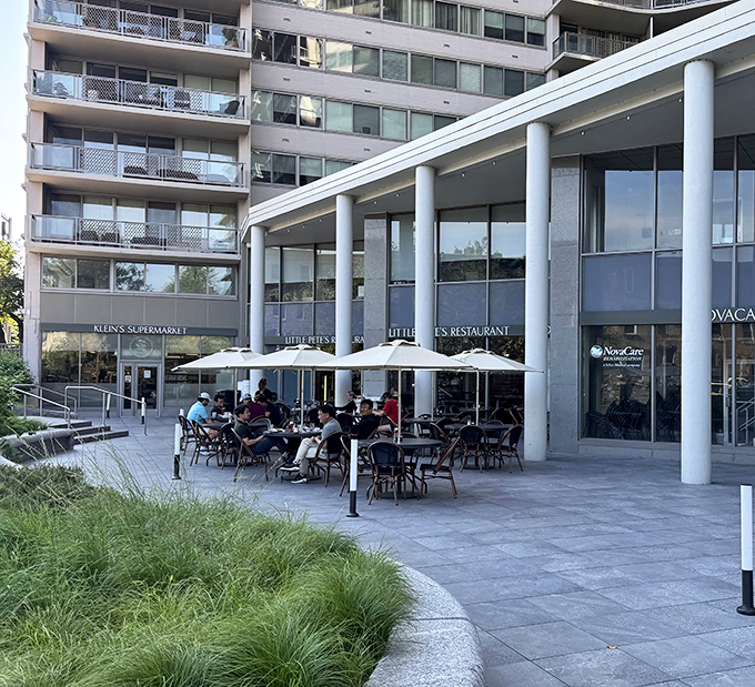 The blue awning of Little Pete's beckons like an old friend, promising comfort food and conversation under those cheerful patio umbrellas.