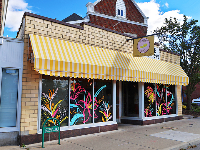 The cheerful yellow-striped awning of Butter Cafe stands out like a breakfast beacon on Brown Street, with vibrant murals promising colorful culinary adventures inside.