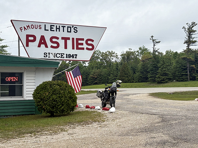 The unassuming exterior of Lehto's Pasties stands like a culinary lighthouse on US-2, beckoning hungry travelers with its iconic triangular sign since 1947.