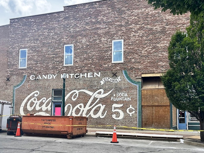 The historic brick fa&ccedil;ade of Flesor's Candy Kitchen stands as a time capsule in downtown Tuscola, complete with vintage Coca-Cola signage promising sweet nostalgia inside.