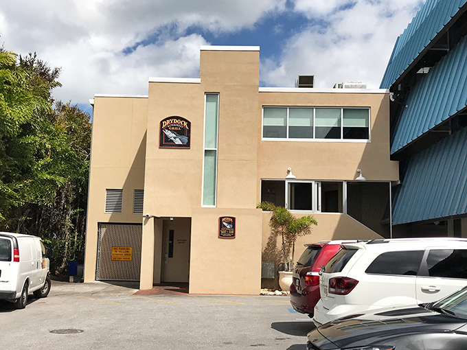 The unassuming beige exterior of Dry Dock Waterfront Grill proves once again that in Florida, architectural modesty often hides culinary magnificence.