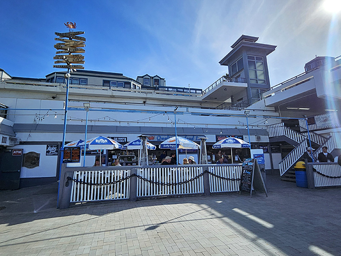 The unassuming entrance to seafood paradise. White picket fences and blue umbrellas welcome you to Quality Seafood, where ocean-to-table isn't a trend&mdash;it's tradition.