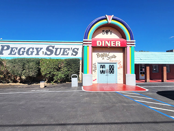 The rainbow-arched entrance to Peggy Sue's stands like a time portal in the Mojave Desert, promising comfort food salvation to weary travelers.