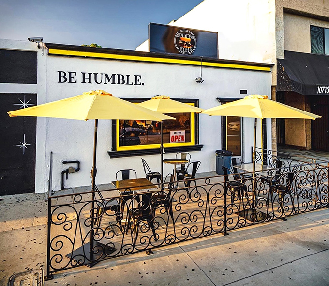 The humble storefront speaks volumes: bright yellow umbrella, wrought iron fence, and that "BE HUMBLE" mantra that perfectly sets the stage for Nashville-style chicken greatness. 