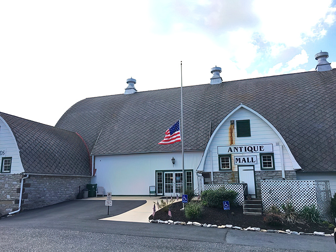 The iconic barn-shaped Crossroads Antique Mall stands like a beacon for treasure hunters, its curved roof promising adventures in antiquing beneath Pennsylvania skies.