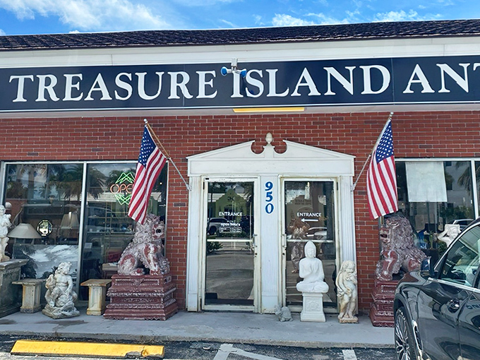 The unassuming exterior of Treasure Island Antiques in Naples belies the wonderland of vintage treasures waiting inside. American flags and stone guardians welcome curious explorers.