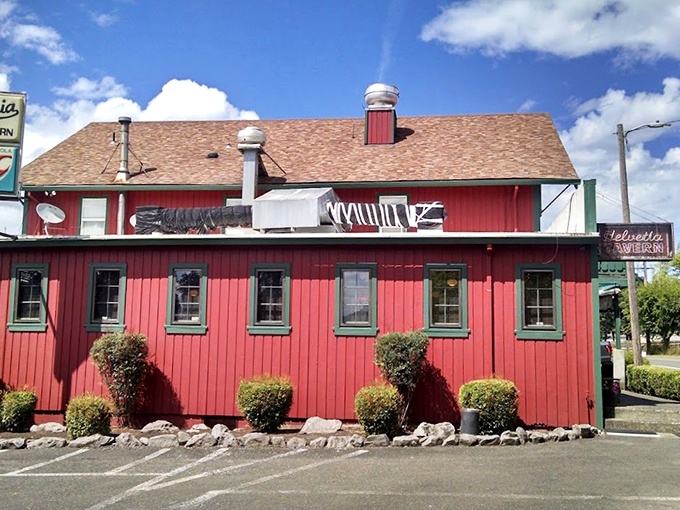 The iconic red exterior of Helvetia Tavern stands like a culinary lighthouse in rural Hillsboro, beckoning hungry travelers with promises of burger perfection.