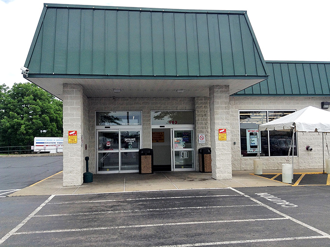 The unassuming exterior of Village Discount Outlet in Akron, where treasure hunters' dreams come true beneath that iconic green roof.