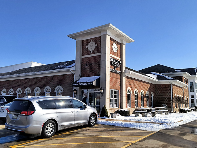 The brick clock tower entrance at Guido's Pizza Haven stands like a culinary lighthouse, beckoning hungry travelers through Chesterland's snow-dusted landscape.