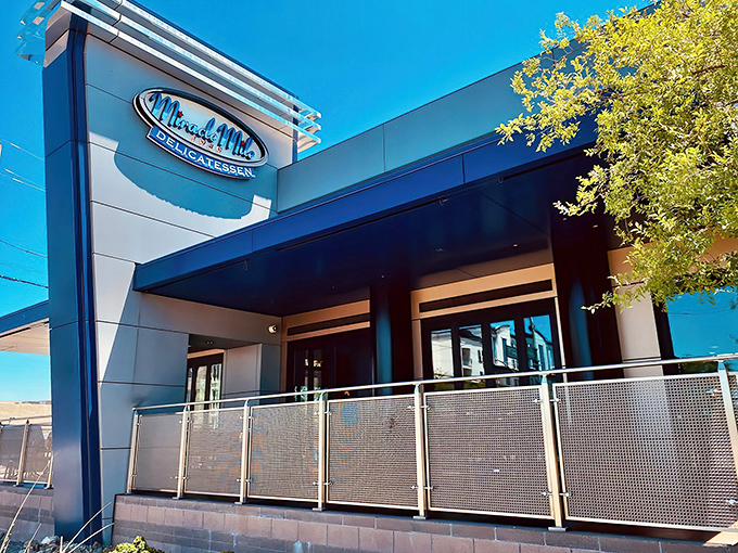 The unassuming exterior of Miracle Mile Deli belies the sandwich paradise within. Like finding a hidden treasure map, that blue sign promises delicious adventures ahead.