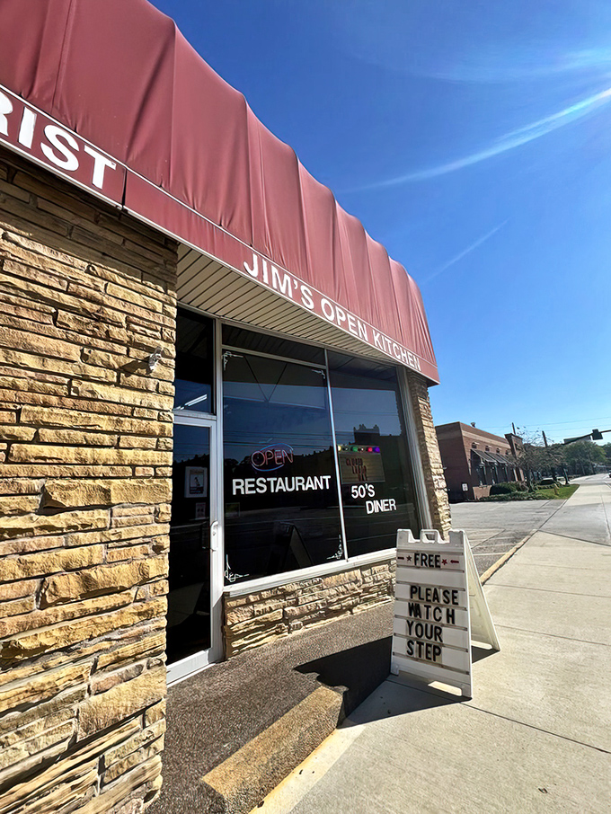The stone facade and bold red awning of Jim's Open Kitchen stands as a beacon of hope for hungry travelers. Watch your step into breakfast paradise!