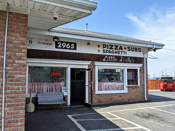 The unassuming brick exterior of Little Sicily's might not scream "culinary destination," but those pink curtains whisper, "Come in, we've got the good stuff."