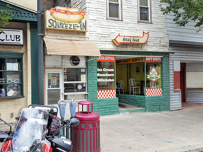 The iconic neon hot dog sign beckons hungry travelers like a lighthouse for comfort food enthusiasts. This sliver of culinary paradise proves good things come in small packages.