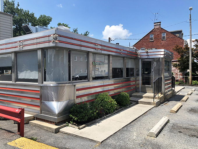 The classic red-striped exterior of Neptune Diner gleams like a time machine parked conveniently in Lancaster, promising nostalgic comfort with every meal.
