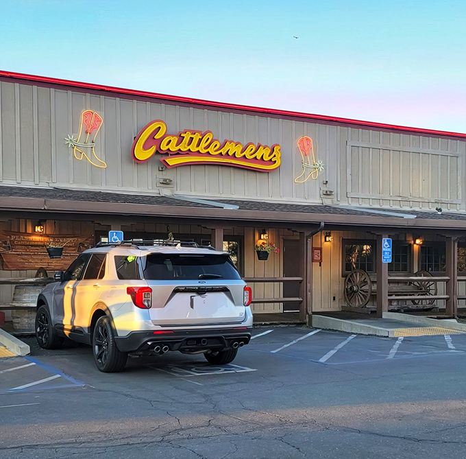 The iconic Cattlemens exterior welcomes hungry travelers with its Western charm and neon cowboy boots. This isn't just dinner—it's a destination.