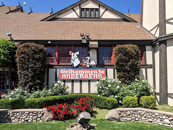 The iconic Tudor-style facade of Pea Soup Andersen's welcomes travelers with its charming "Velkommen" sign and colorful landscaping.