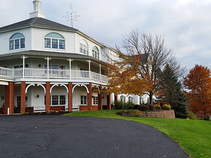 The grand white and brick exterior of Amish Door Restaurant stands like a beacon of comfort food amid Ohio's rolling countryside. That wraparound porch practically whispers "come sit a while."