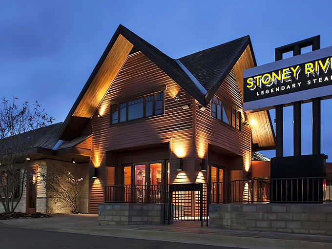 The lodge-inspired architecture of Stoney River glows at dusk, promising warmth inside that matches the amber lighting outside.