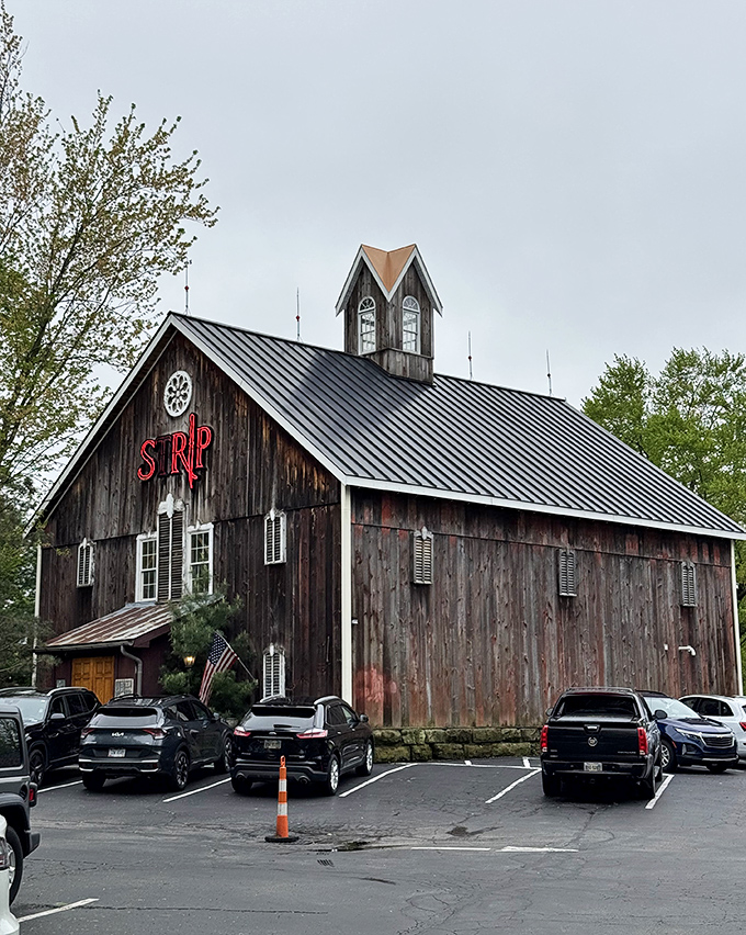 Not your average barn raising! Strip Steakhouse's weathered exterior and glowing red sign promise rustic charm with a carnivorous twist.