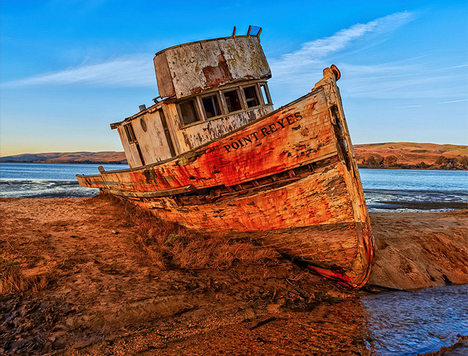 Nature's light show transforms the abandoned Point Reyes boat into a sunset masterpiece. The weathered hull glows like embers against the cotton candy sky.