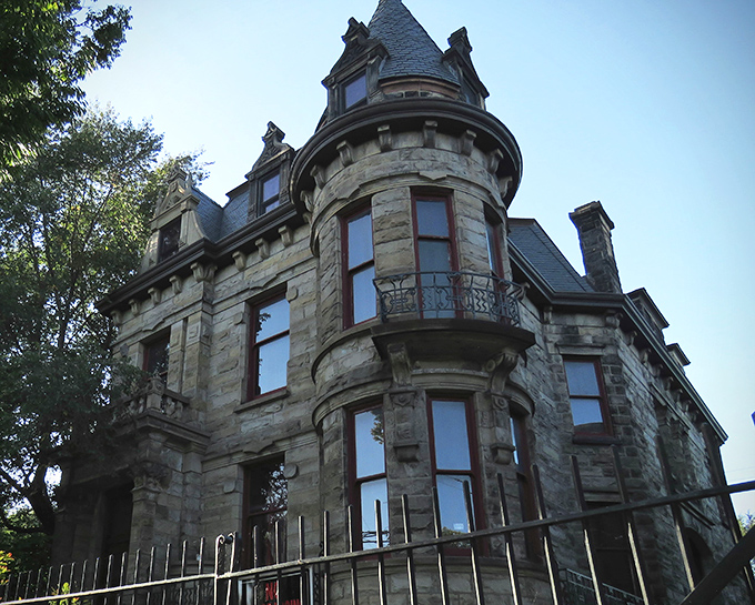 The imposing stone facade of Franklin Castle looms against a moody sky, its turrets and balconies whispering tales of Cleveland's Gothic past.