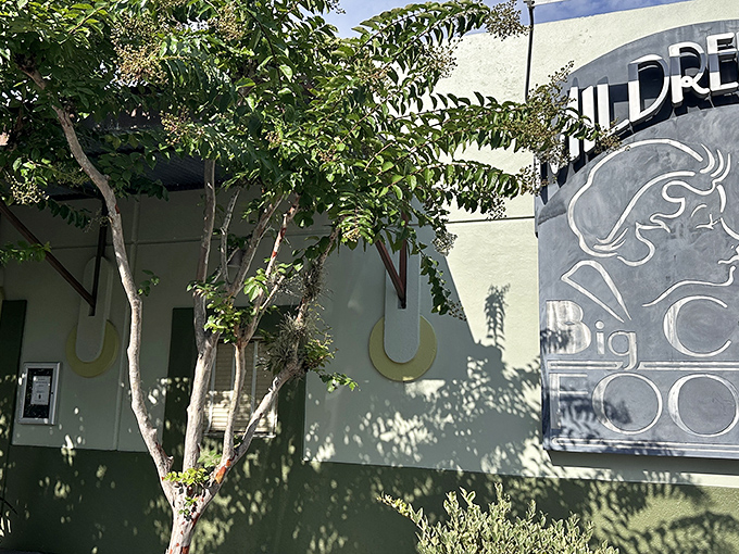 The unassuming exterior of Mildred's Big City Food, where leafy trees provide shade and a hint of the natural ingredients awaiting inside.