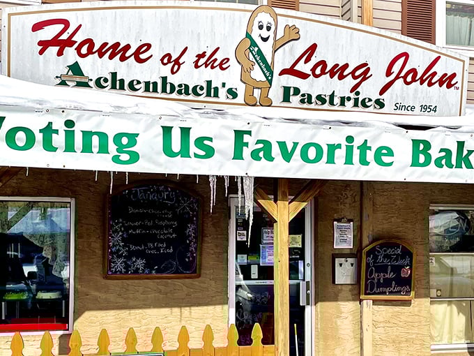 The welcoming facade of Achenbach's Pastries, where vibrant marigolds and hanging baskets create the perfect prelude to the sweet treasures within.