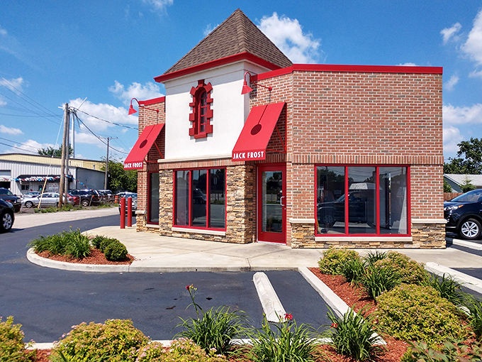 The white building with bold red signage stands like a beacon of sweetness on Pearl Road, promising "EVERY BATCH FRESH SCRATCH" &ndash; the donut lover's siren call.