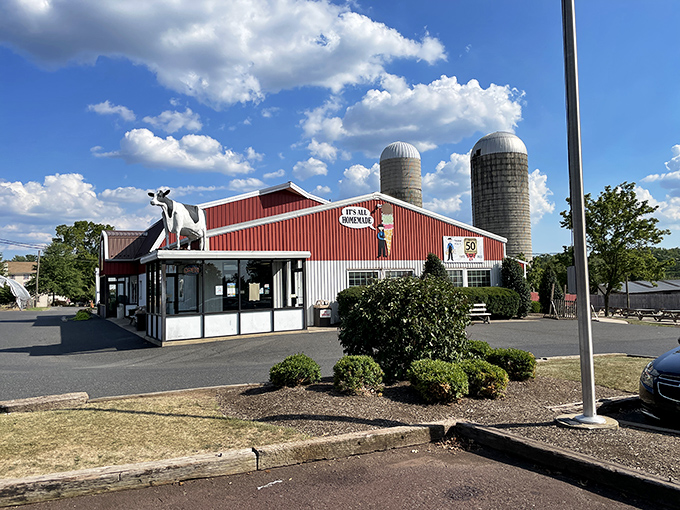 The iconic red barn of Freddy Hill Farms stands like a dairy cathedral against Pennsylvania skies, complete with the guardian cow statue keeping watch over ice cream pilgrims.