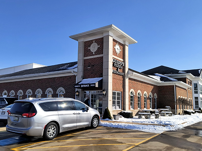 The brick clock tower entrance at Guido's Pizza Haven stands like a culinary lighthouse, beckoning hungry travelers through Chesterland's snow-dusted landscape.