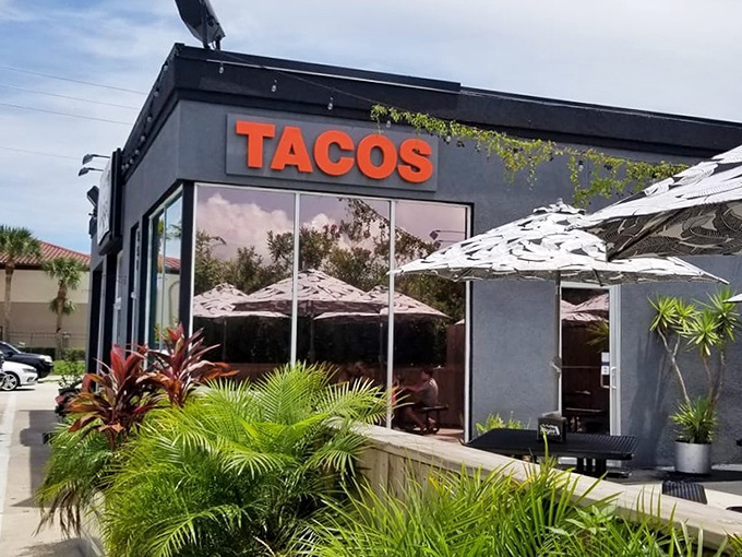 The sleek black exterior with bold orange "TACOS" signage stands as a modern beacon of flavor amid St. Augustine's historic charm.