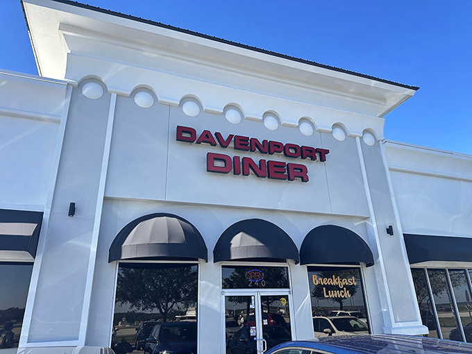 The gleaming white exterior of Davenport Diner stands like a beacon of breakfast hope against the Florida sky, promising culinary comfort within those navy-awninged doors.