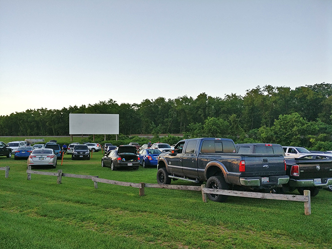 Cars line up at dusk, anticipation building as the massive screen awaits the night's feature. A perfect summer evening under Ohio stars.