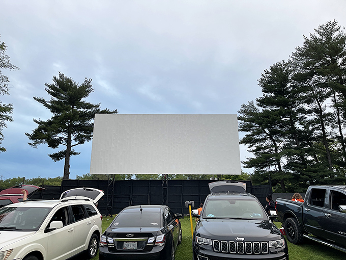 Cars line up at dusk, anticipation building as the massive screen awaits the night's feature. A perfect summer evening under Ohio stars.