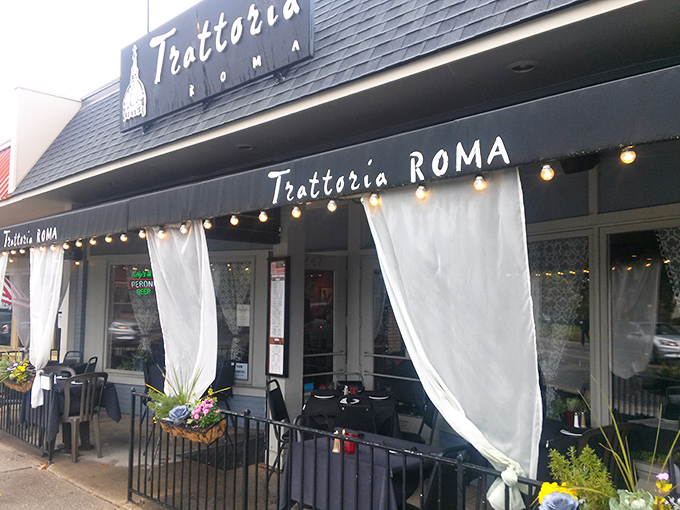 The evening glow of Trattoria Roma beckons like a lighthouse for the pasta-starved, promising Italian salvation behind those flowing curtains.