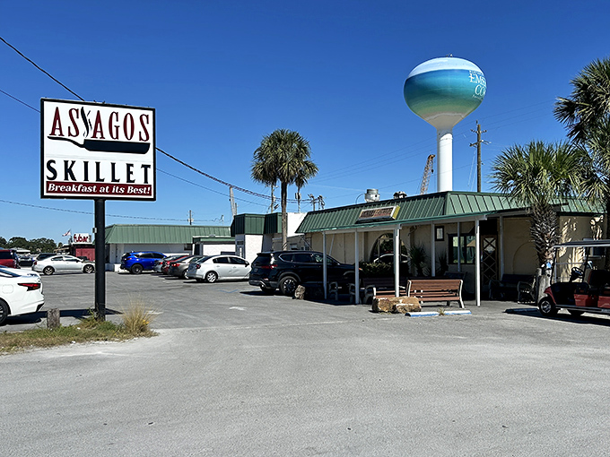The unassuming exterior of Asiago's Skillet, where breakfast dreams come true beneath Fort Walton Beach's iconic water tower. Hidden gems rarely advertise themselves.