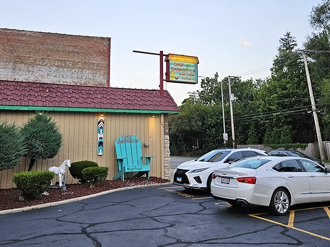 The unassuming exterior of Chef Shangri-La hides its tropical treasures like a suburban speakeasy. That turquoise chair is your first clue to paradise.