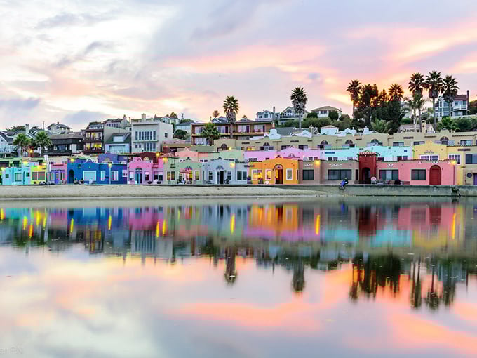 The famous rainbow-colored Venetian Court cottages create a perfect mirror image on Soquel Creek at sunset. California coastal magic at its finest.