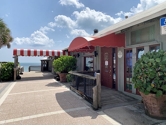 Old Florida charm greets you at Ocean Grill's entrance, where swaying palms and turquoise railings promise seafood paradise awaits just steps from the Atlantic.