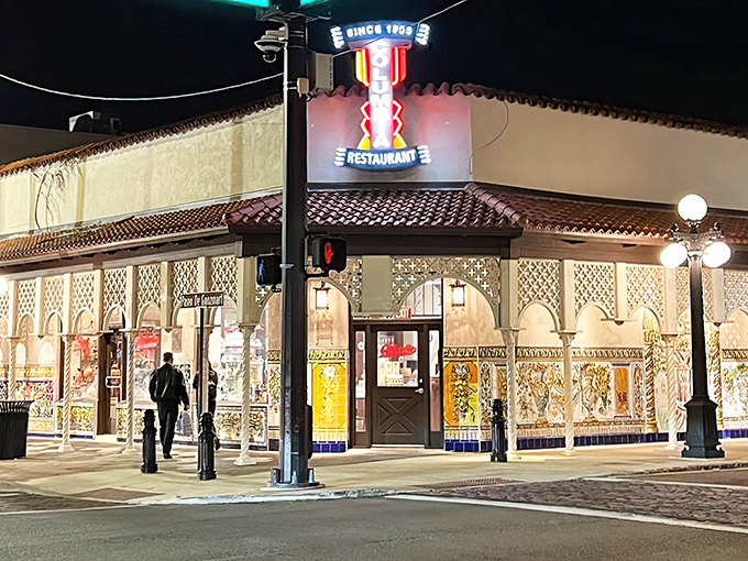 The Columbia's façade glows like a Spanish palace at night, its ornate tilework and dramatic lighting beckoning hungry travelers like a culinary lighthouse.