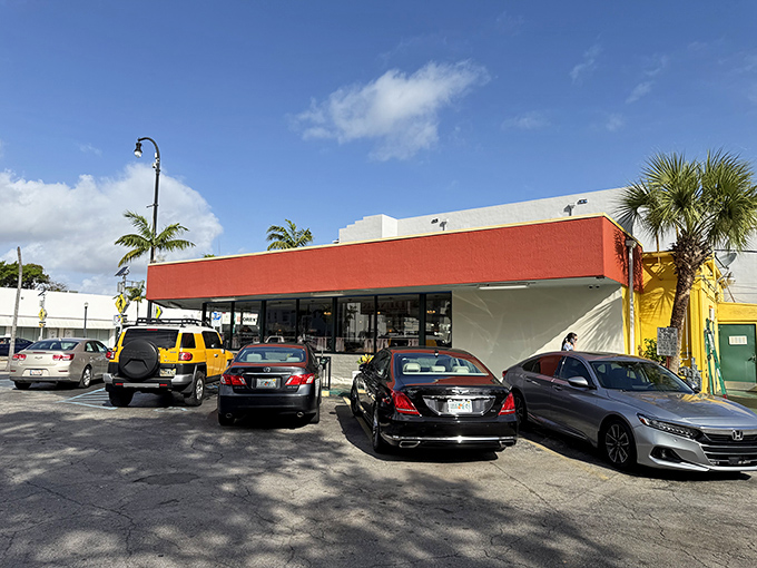 The iconic red-trimmed exterior of Jimmy's Eastside Diner stands like a time capsule of American dining culture, palm trees swaying as if to welcome hungry patrons.