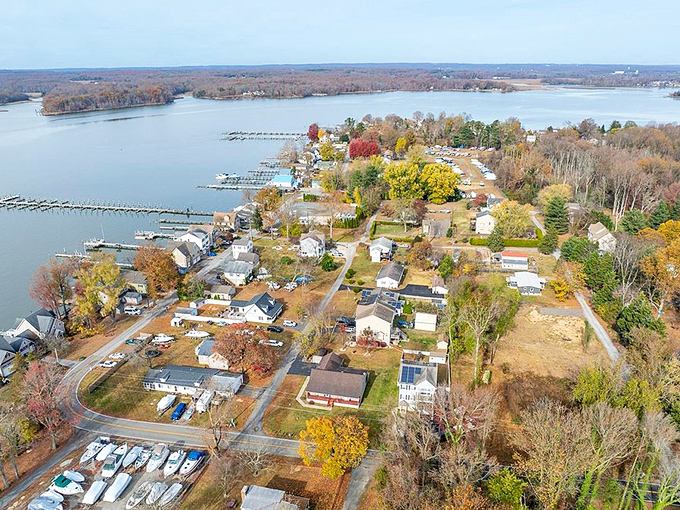 Aerial splendor of Elkton's waterfront community, where retirement dreams meet reality. Fall foliage frames cozy homes nestled along peaceful waterways.