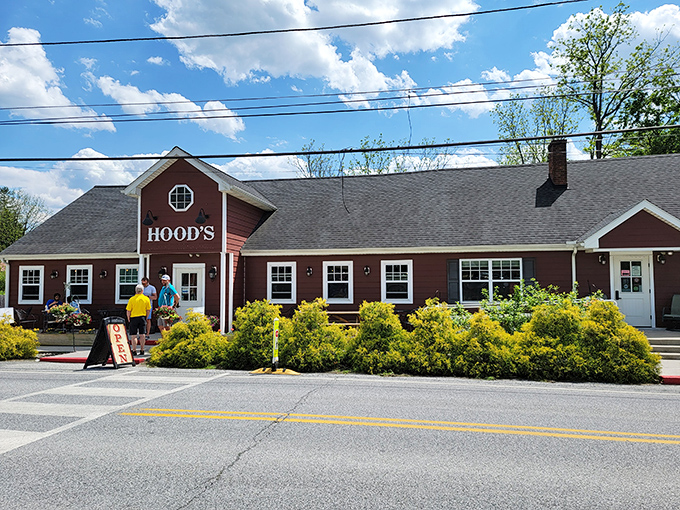 The burgundy farmhouse exterior with its cheerful yellow walkway and seasonal mums isn't just curb appeal&mdash;it's a promise of homestyle comfort waiting inside.