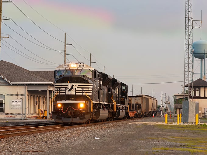 The Norfolk Southern freight train rumbles through downtown Harrington, a living reminder of the town's railroad heritage. In the distance, that iconic water tower stands sentinel over this peaceful community.