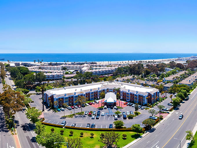 Port Hueneme's aerial view reveals what developers dream about at night&mdash;pristine beaches, Spanish-style architecture, and that perfect California coastline stretching into misty mountains.