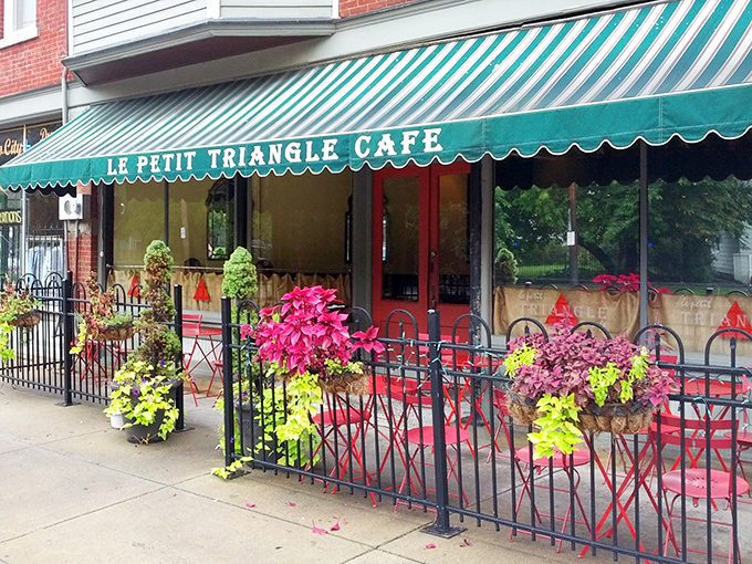 The iconic green and white striped awning of Le Petit Triangle Cafe beckons like a Parisian whisper in Cleveland's Ohio City neighborhood. Sidewalk dining never looked so inviting.